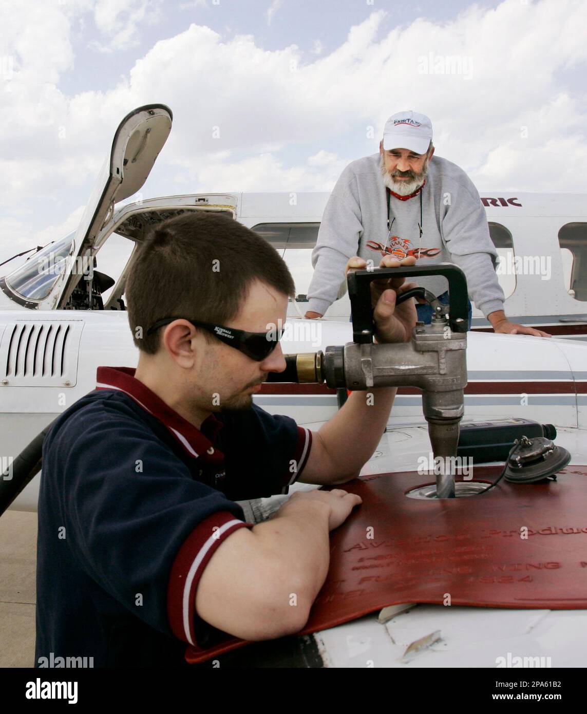 Bob Grice, left, refuels Dale Roark's plane at the DuPage Airport in ...