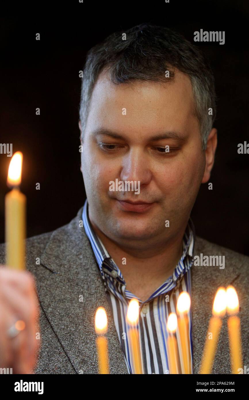 Serbian Defense Minister Dragan Sutanovac lights a candle during his ...