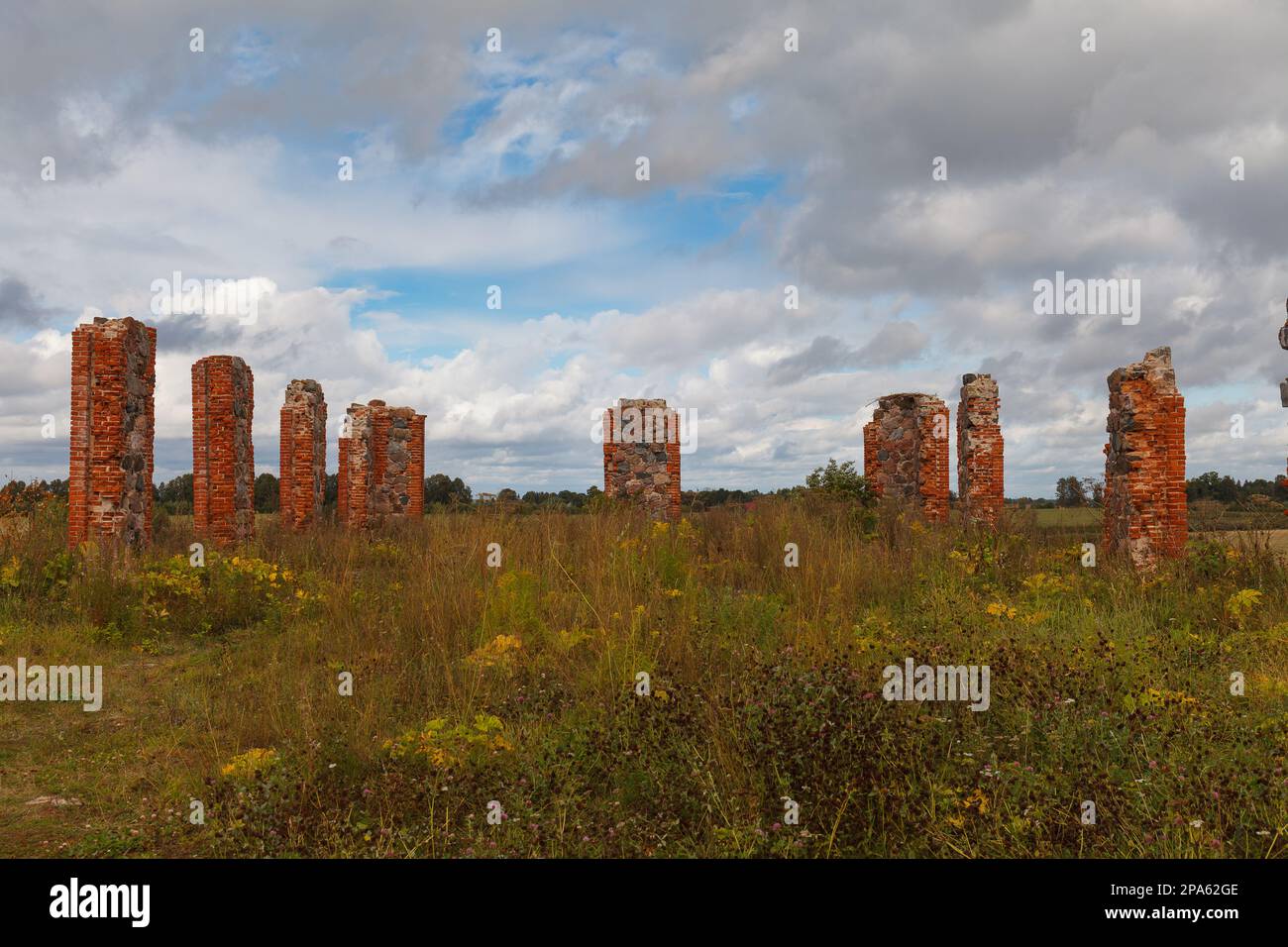 ruins of an old barn made of boulders and red bricks in the middle of a ...