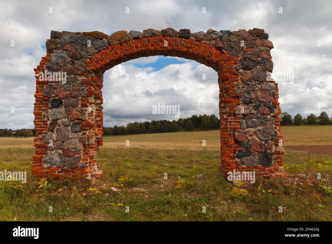 ruins of an old barn made of boulders and red bricks in the middle of a ...