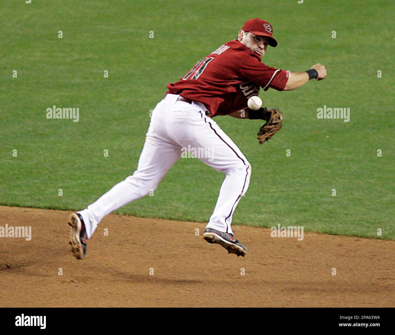 Arizona Diamondbacks shortstop Augie Ojeda spins and throws to first on ...