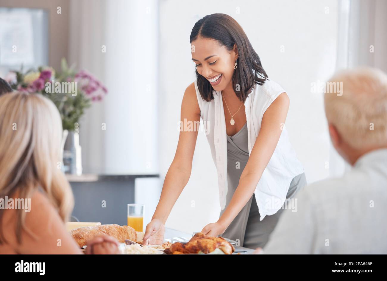 Happy woman hosting food at dinner table in home, house and dining room ...