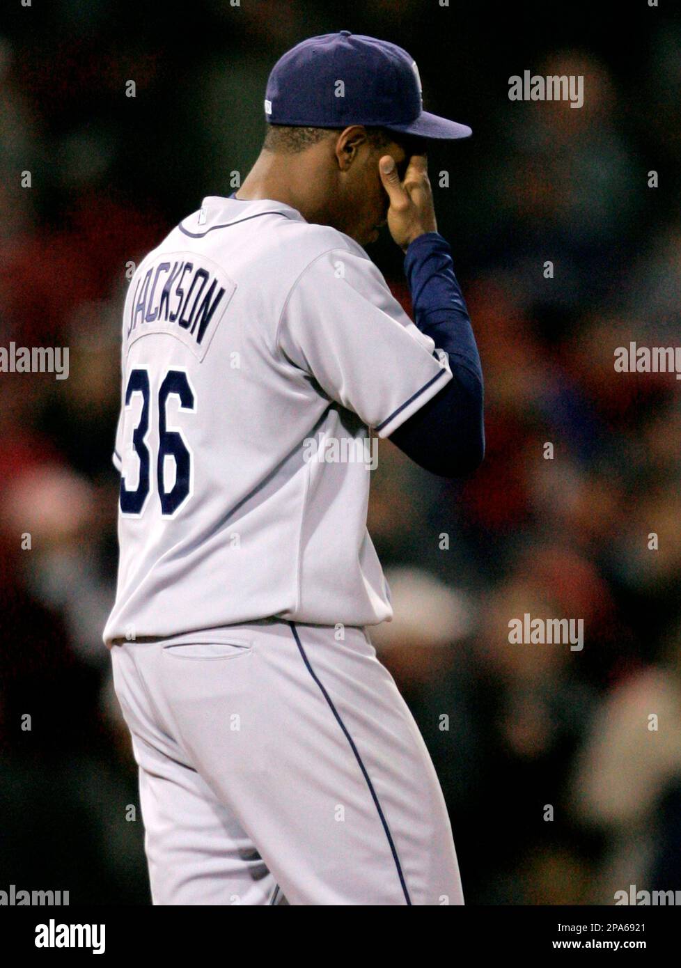 Tampa Bay Rays starter Edwin Jackson wipes his face as he walks back to ...