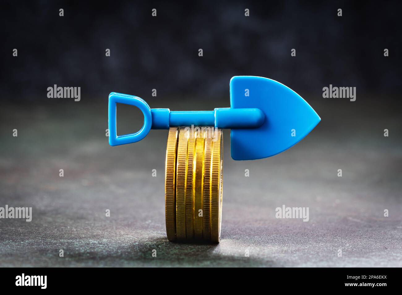 Some cryptocurrency coins with blue shovel on rough grunge surface ...