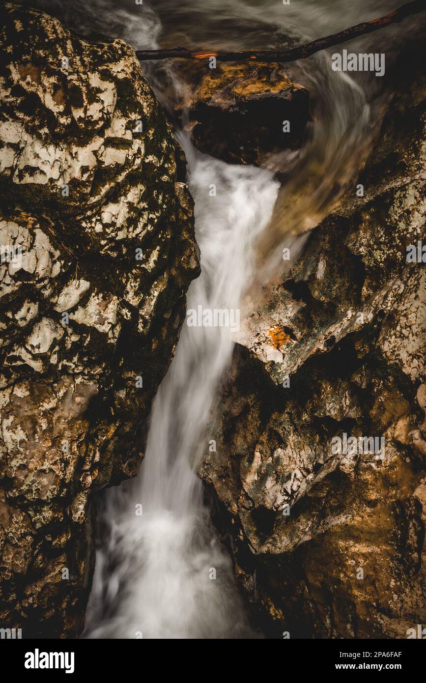 A majestic waterfall cascading down a rugged cliffside into a tranquil ...