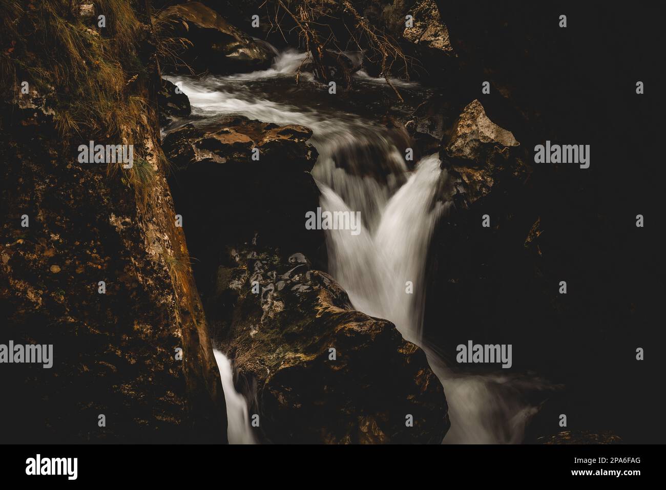 A stunning nighttime scene featuring a small cascading waterfall ...