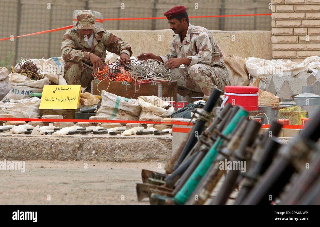 Iraqi army soldiers looks through a seized weapons cache in the ...