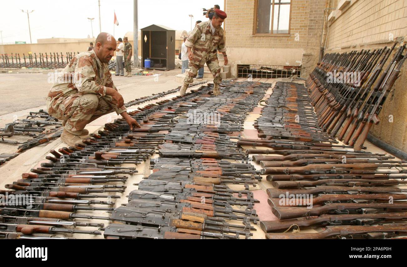 Iraqi army soldiers looks through a seized weapons cache in the ...