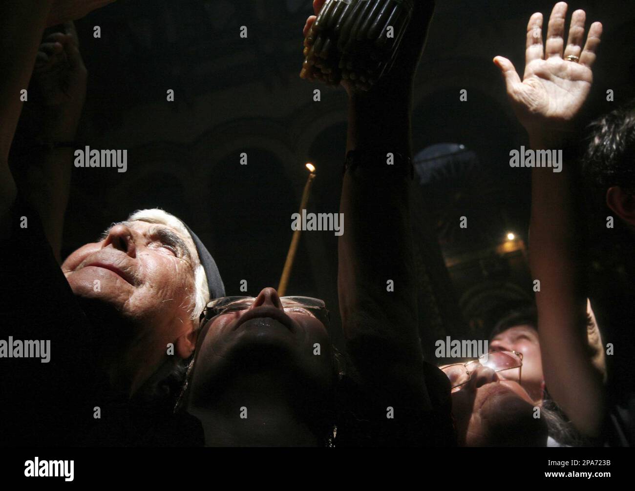 Greek Orthodox pilgrims pray as a stream of light enters the Church of ...