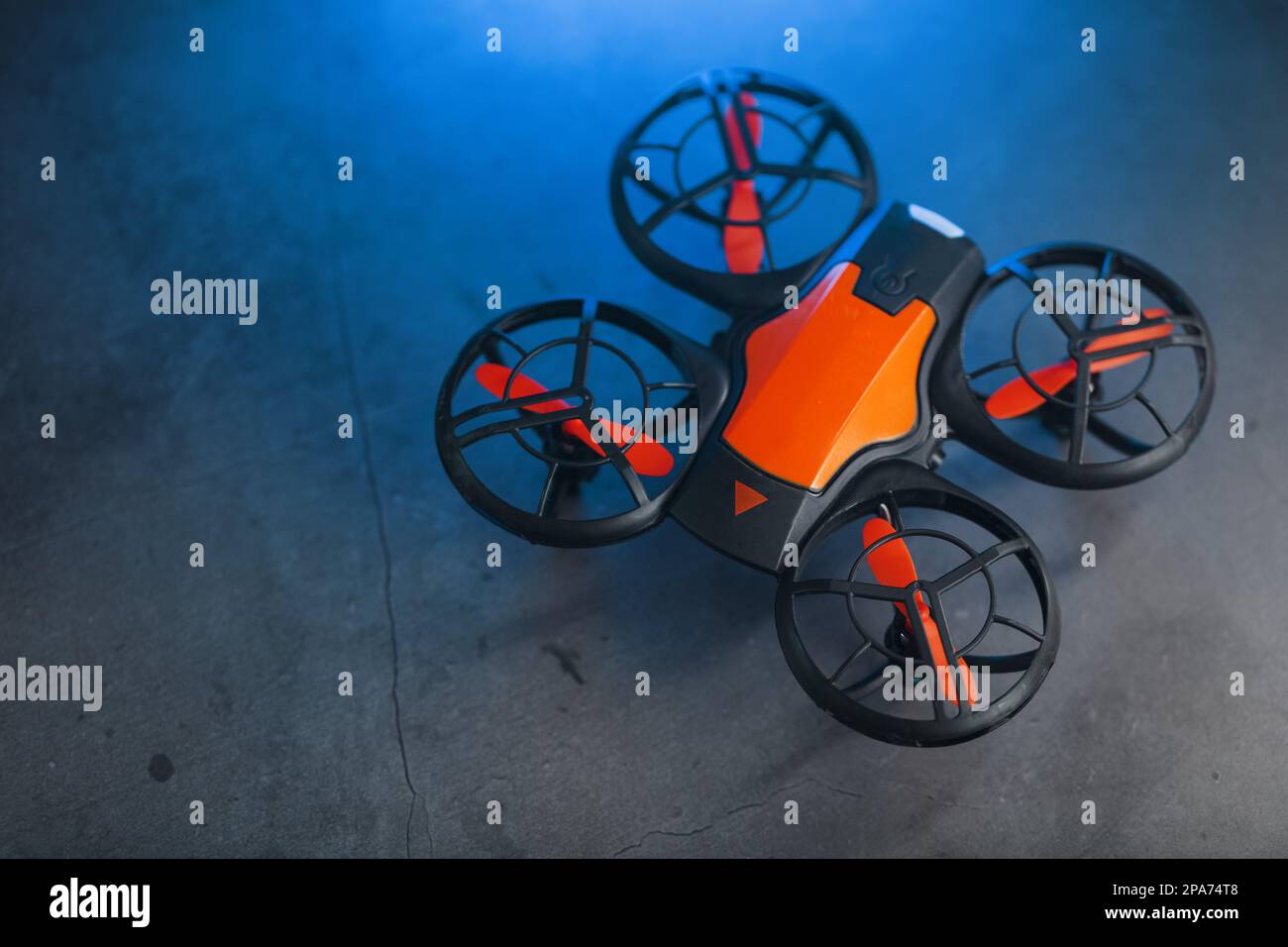 Gaming orange mini drone on a dark background for control from a ...