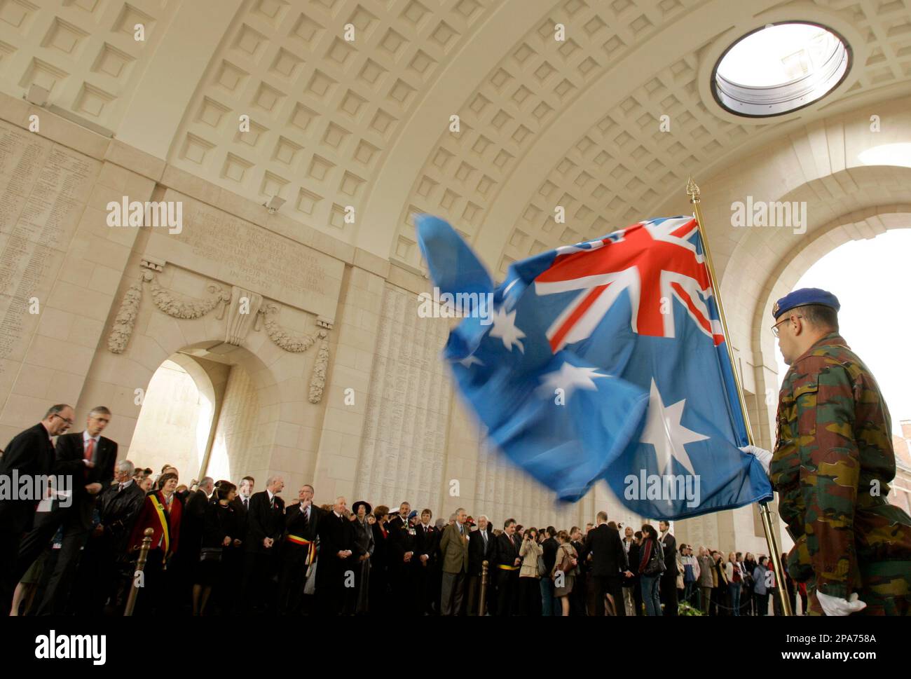 A Belgian soldier holds the Australian flag at the Menin Gate during an ...