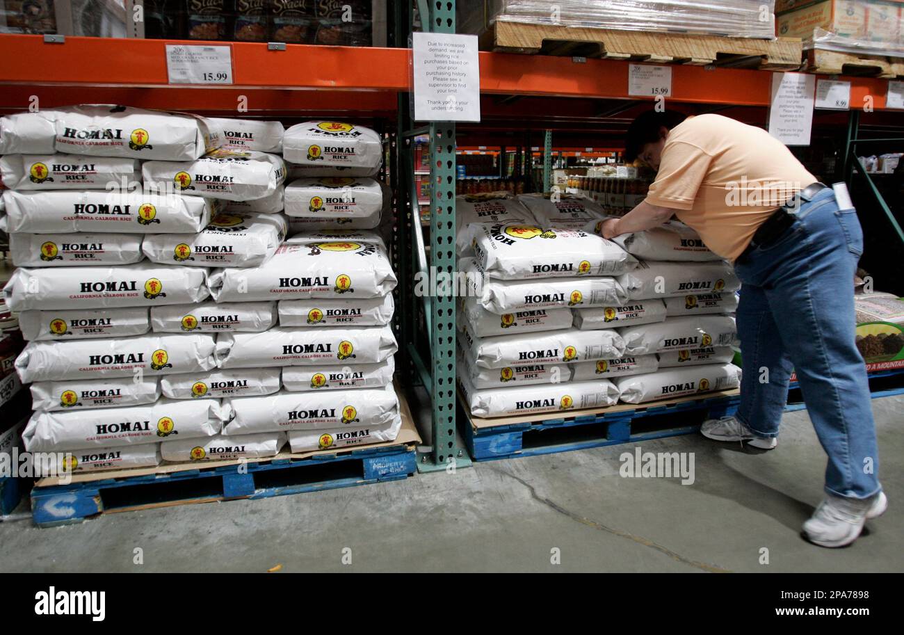 A Costco worker arranges bags of rice at a Costco store in Mountain ...