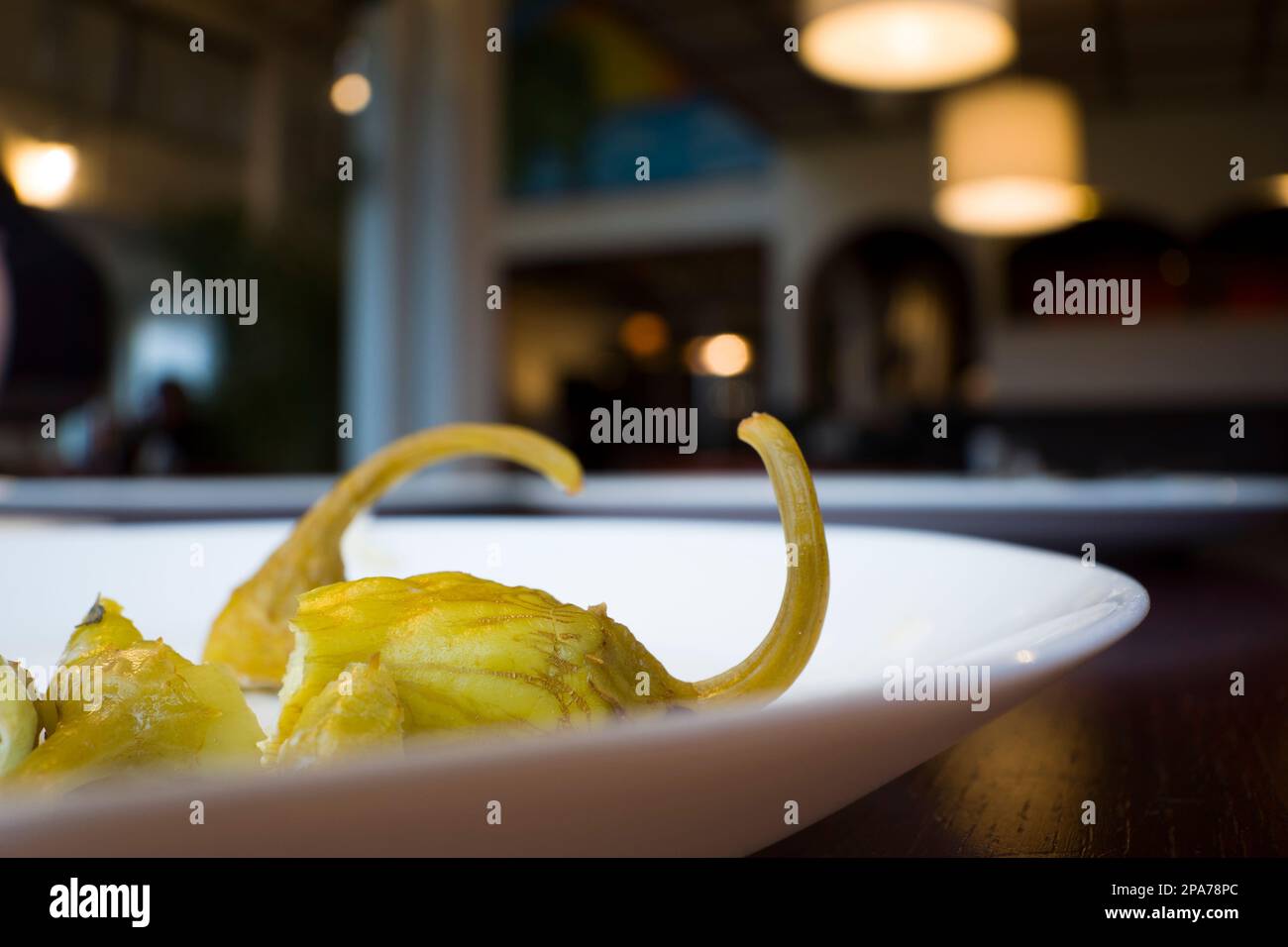 Pickled pepperoni green bitten off tails on white plate leftovers after ...