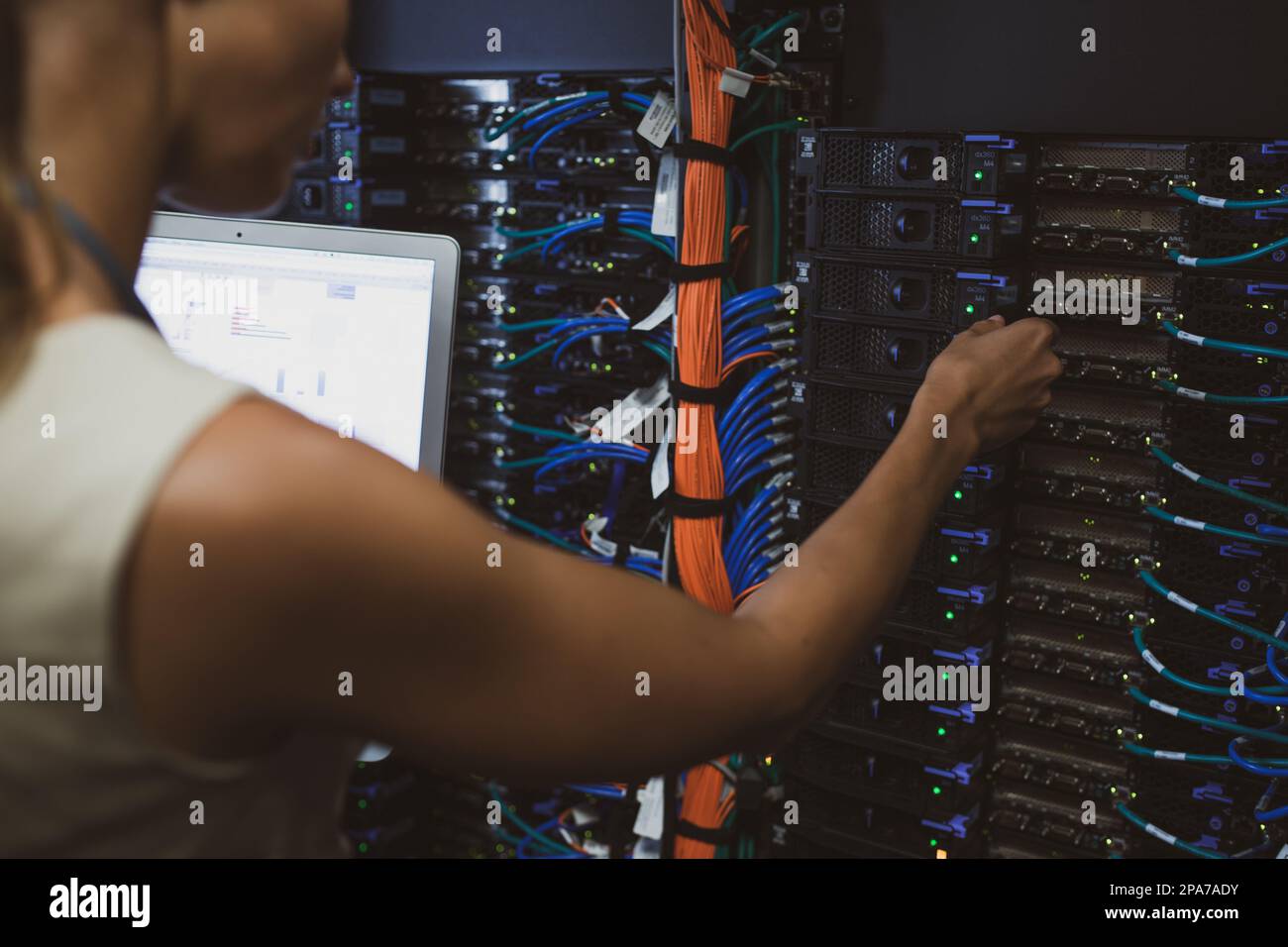IT engineer standing amid working server racks doing routine ...