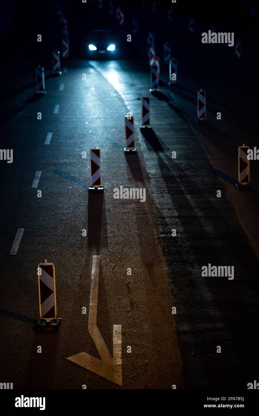 Cars on a road with road closure. Works on the road. Night traffic ...