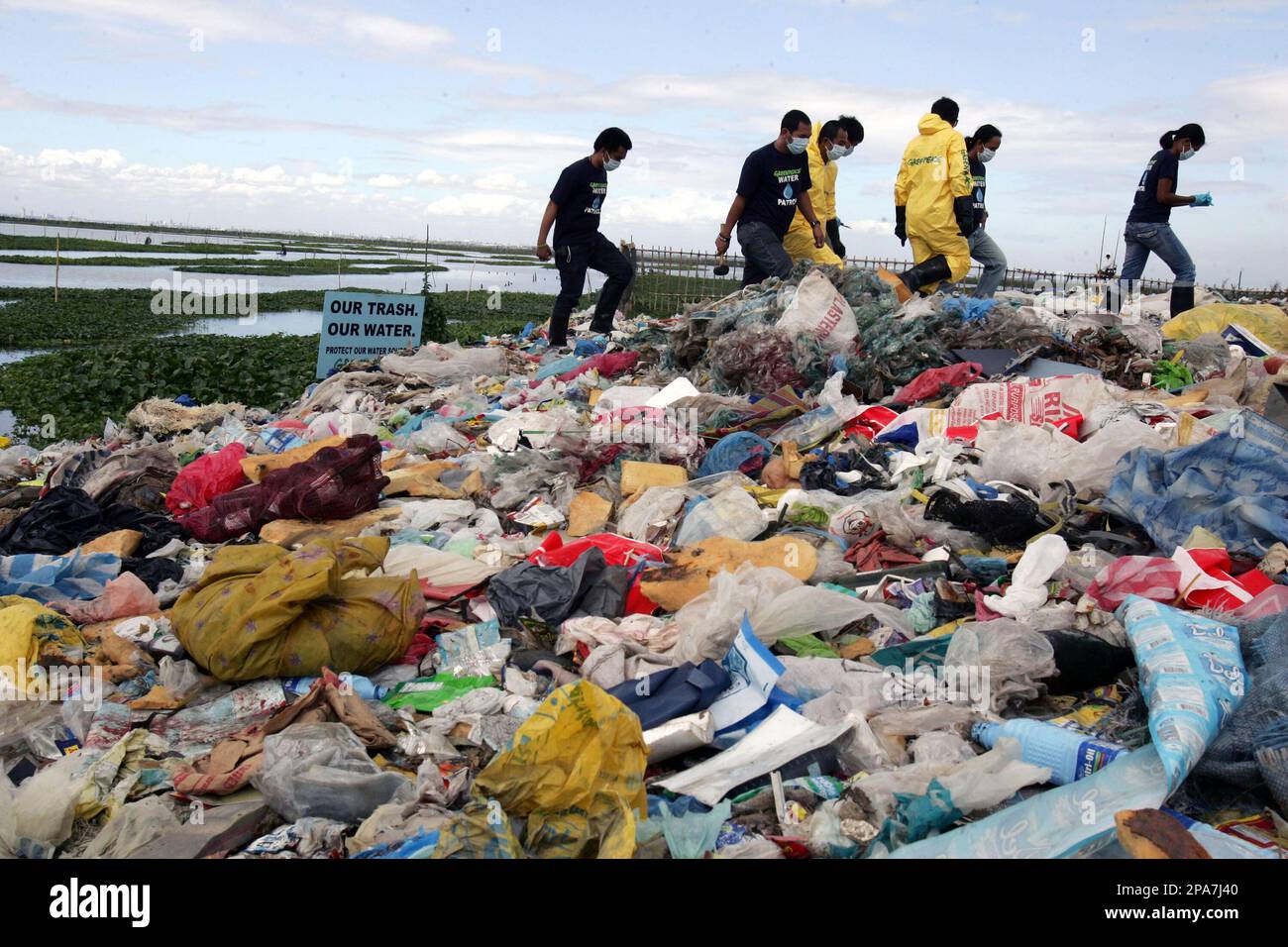 Greenpeace activists walk away after taking water samples to examine ...