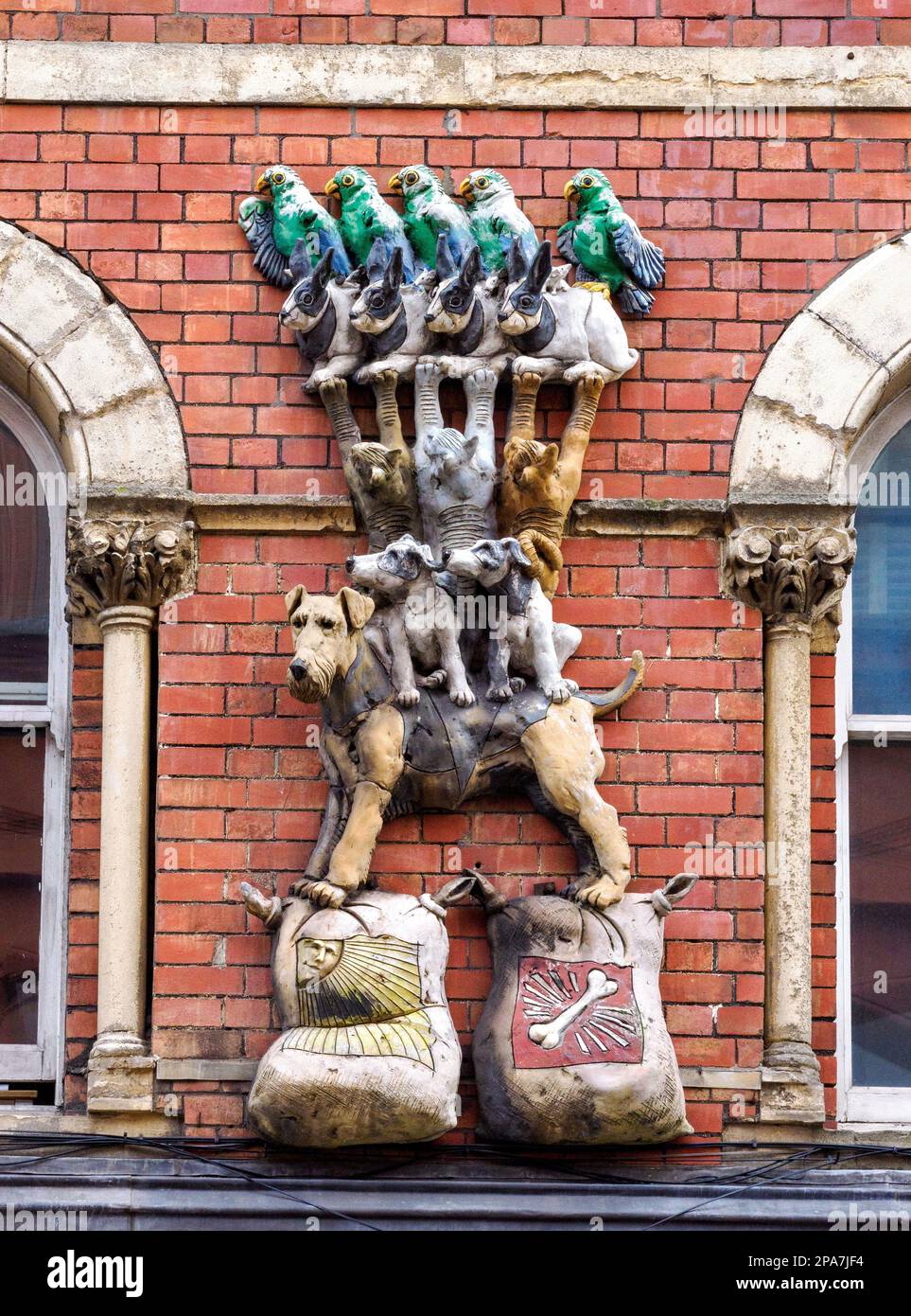 Amusing wall sculpture featuring dogs cats rabbits and parrots above a ...