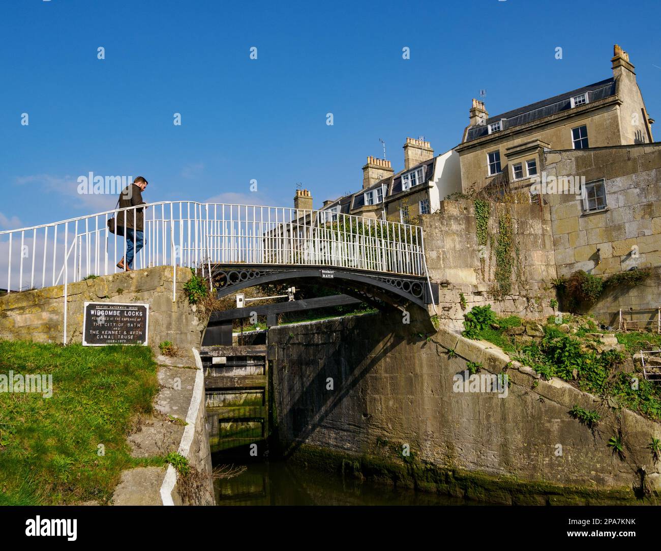 Man crossing a cast iron footbridge at Widcombe Locks on the Kennet and ...