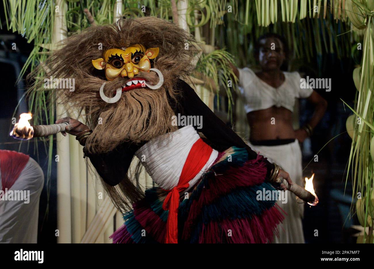 A traditional Sri Lankan dancer performs with a mask on during "Daha ...