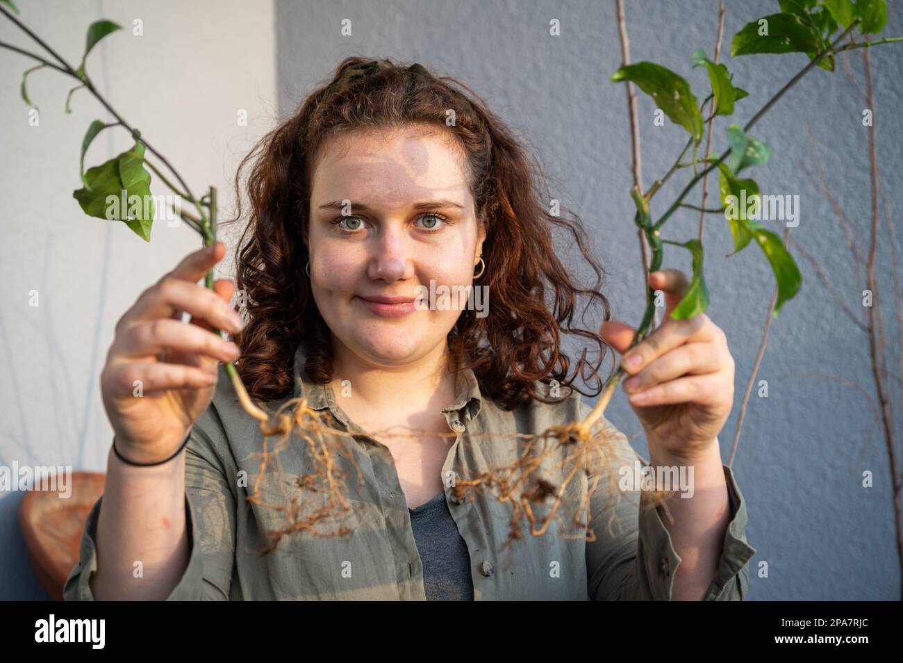 Woman with brown curly hair is smiling and looking at camera while ...