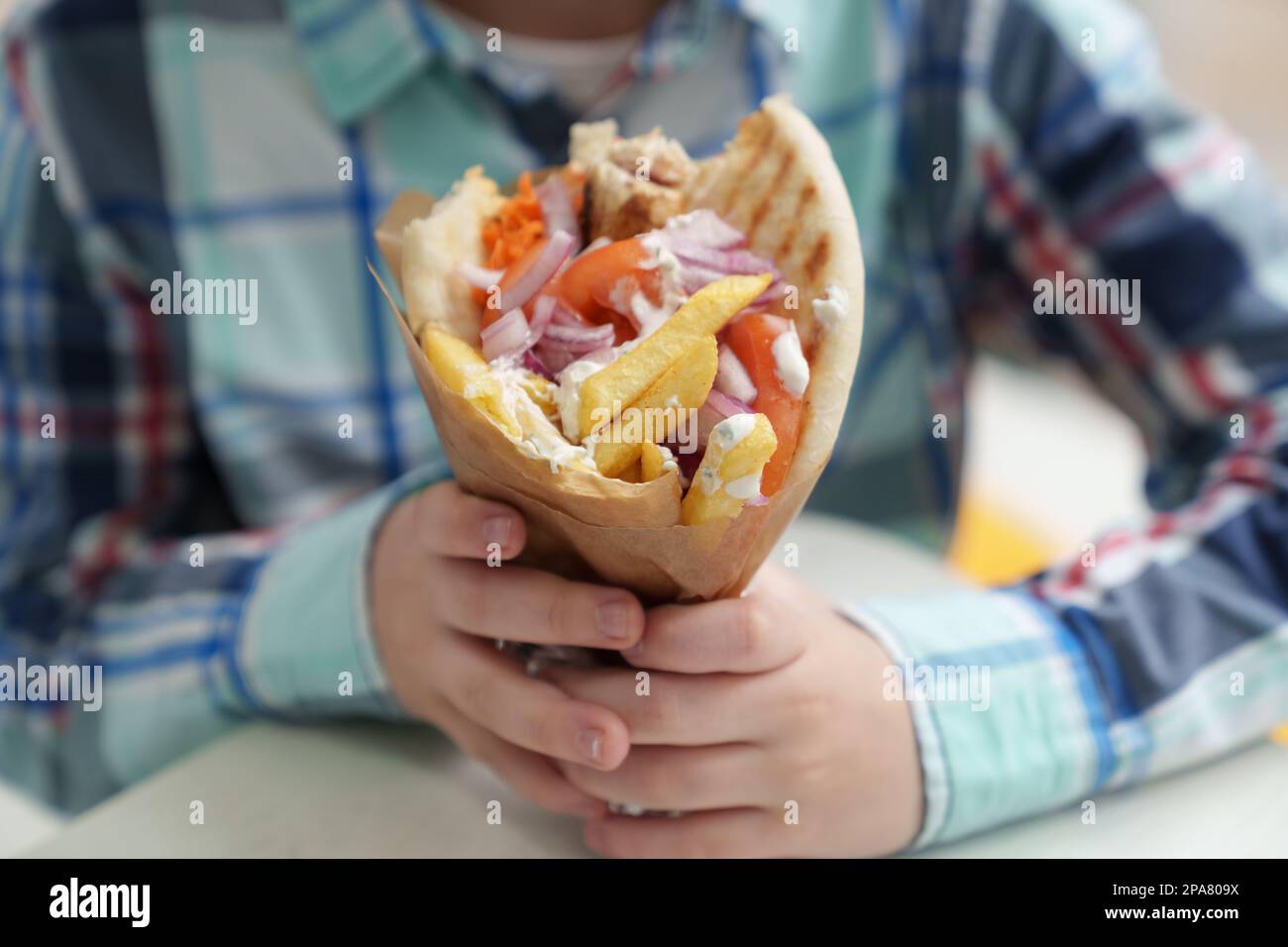 Little boy eating Greek fast food in a restaurant. Close up photo of ...