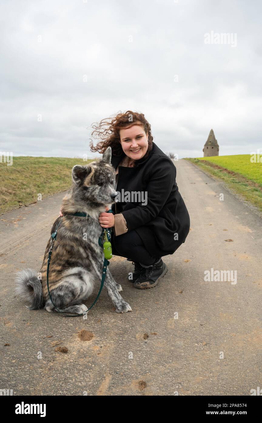 Woman with brown curly hair and black coat is smiling and looking at ...
