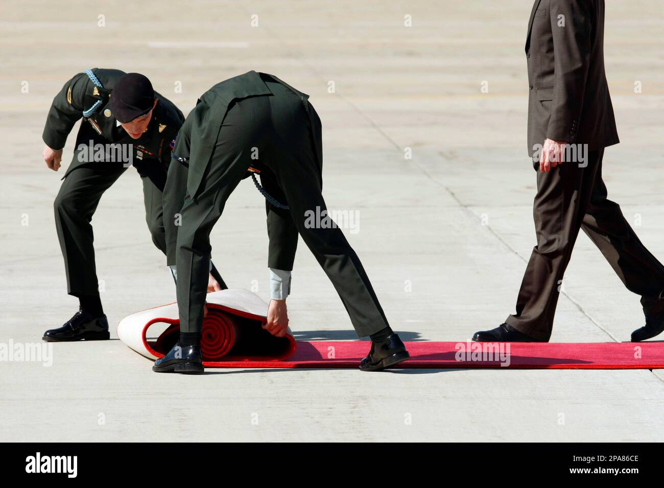 Military personnel roll out a red carpet before the arrival ceremony ...