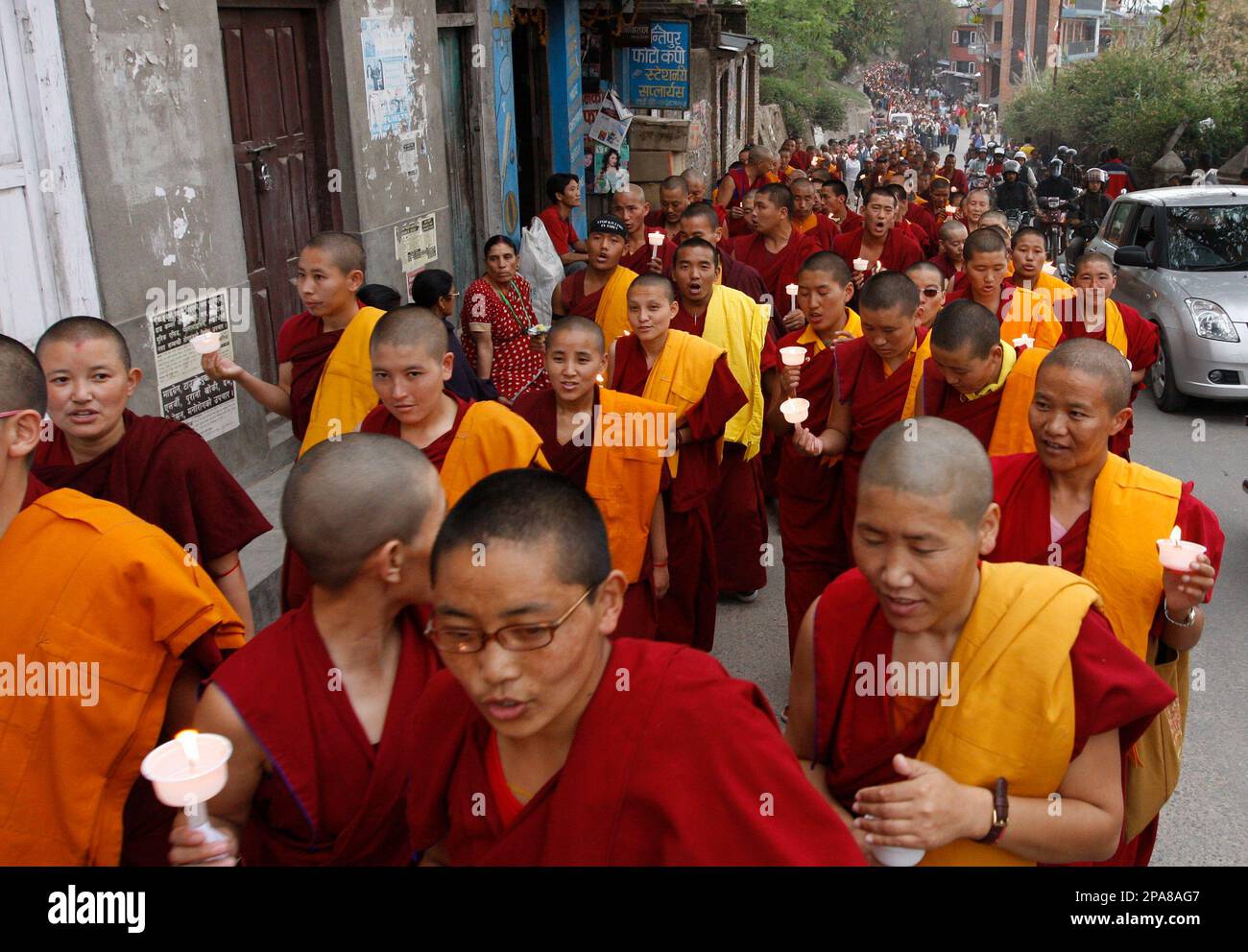 Buddhist monks and nuns chant as they walk around a temple to pray for ...