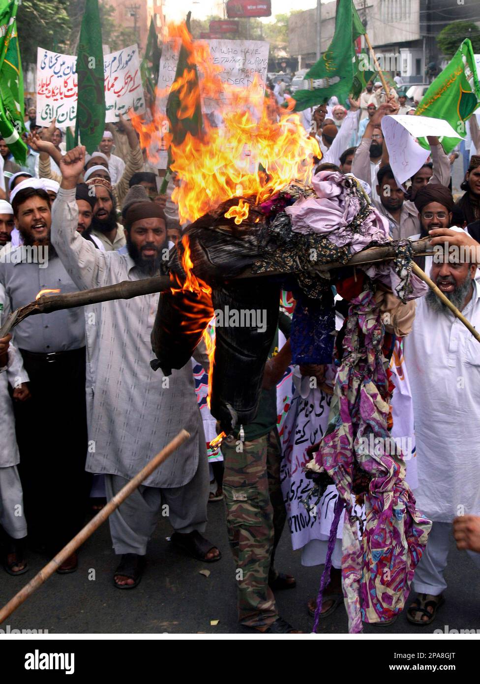 Supporters of Jamat Ahl-e-Sunnat, a Pakistani Islamic party, burn an ...