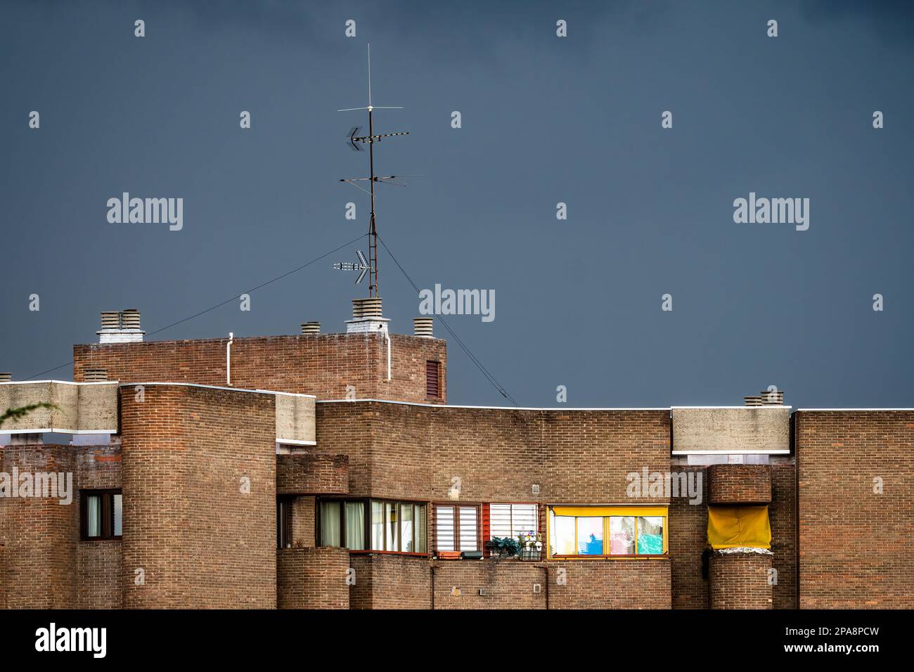Residential brick building in the city against dark cloudy sky. Real ...