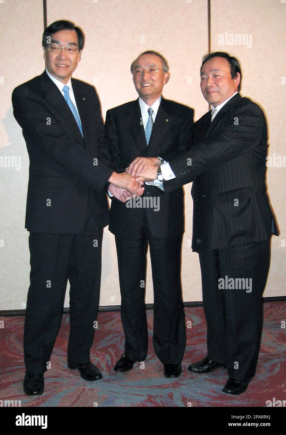 Toyota Motor Corp. President Katsuaki Watanabe, center, smiles with ...