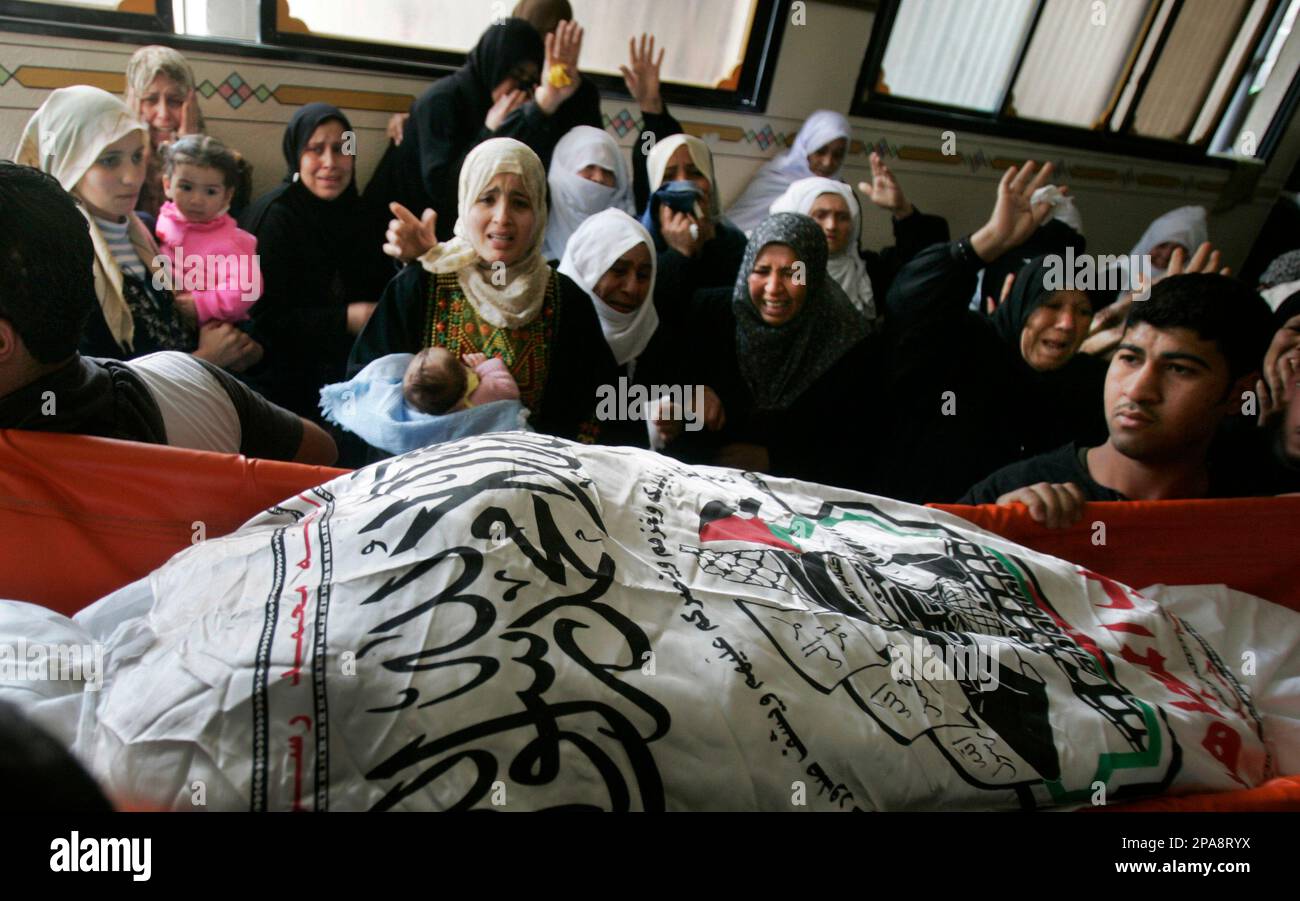 Palestinian relatives mourn during the funeral of two members of the ...