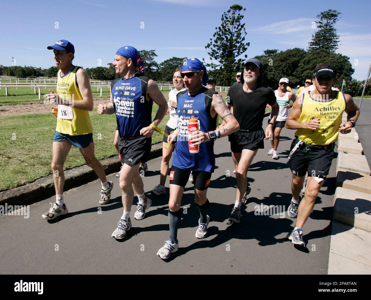 Blind British runner Dave Heeley, second left, runs with his guide ...