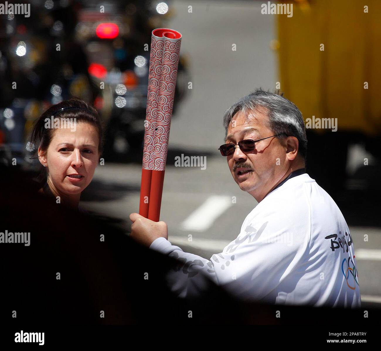 Torch runners Andrea Vincent, left, and Ed Lee hold the torch Wednesday ...