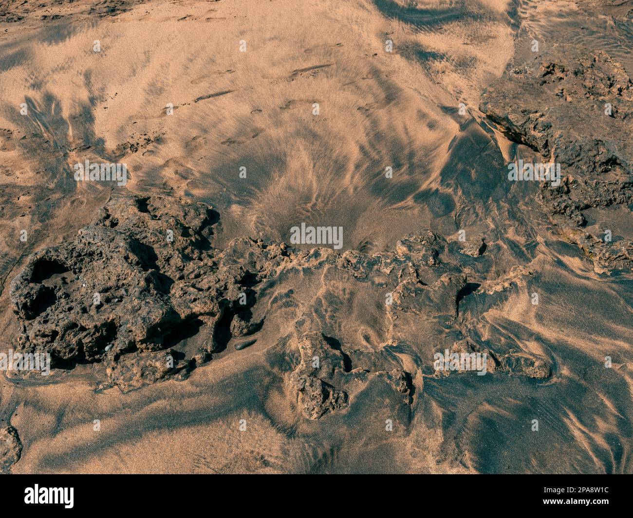 Background with abstract sand shapes created by the waves after washing ...