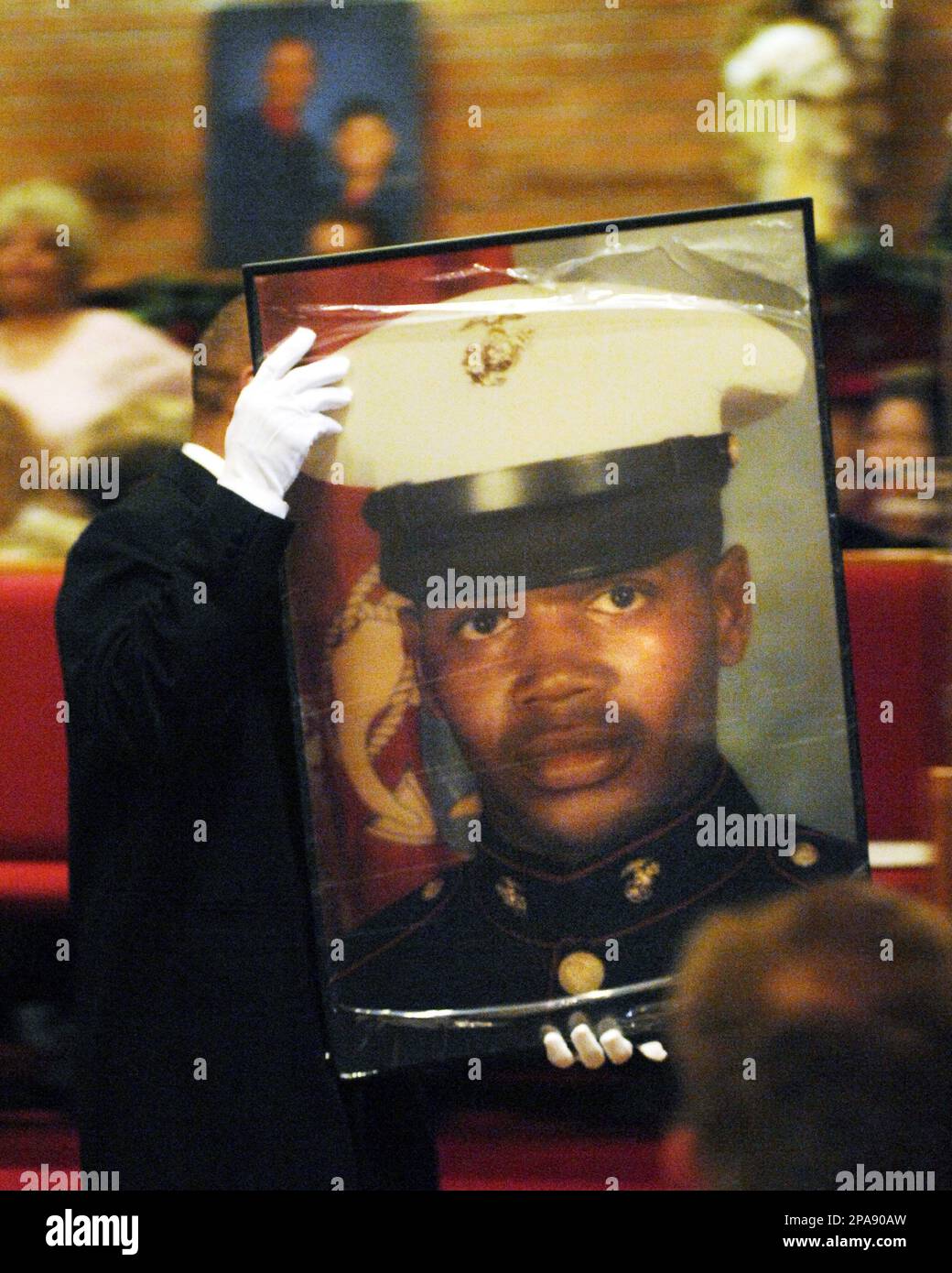 An usher carried a photo of Paul Johnson-Reuben, a former Marine who ...