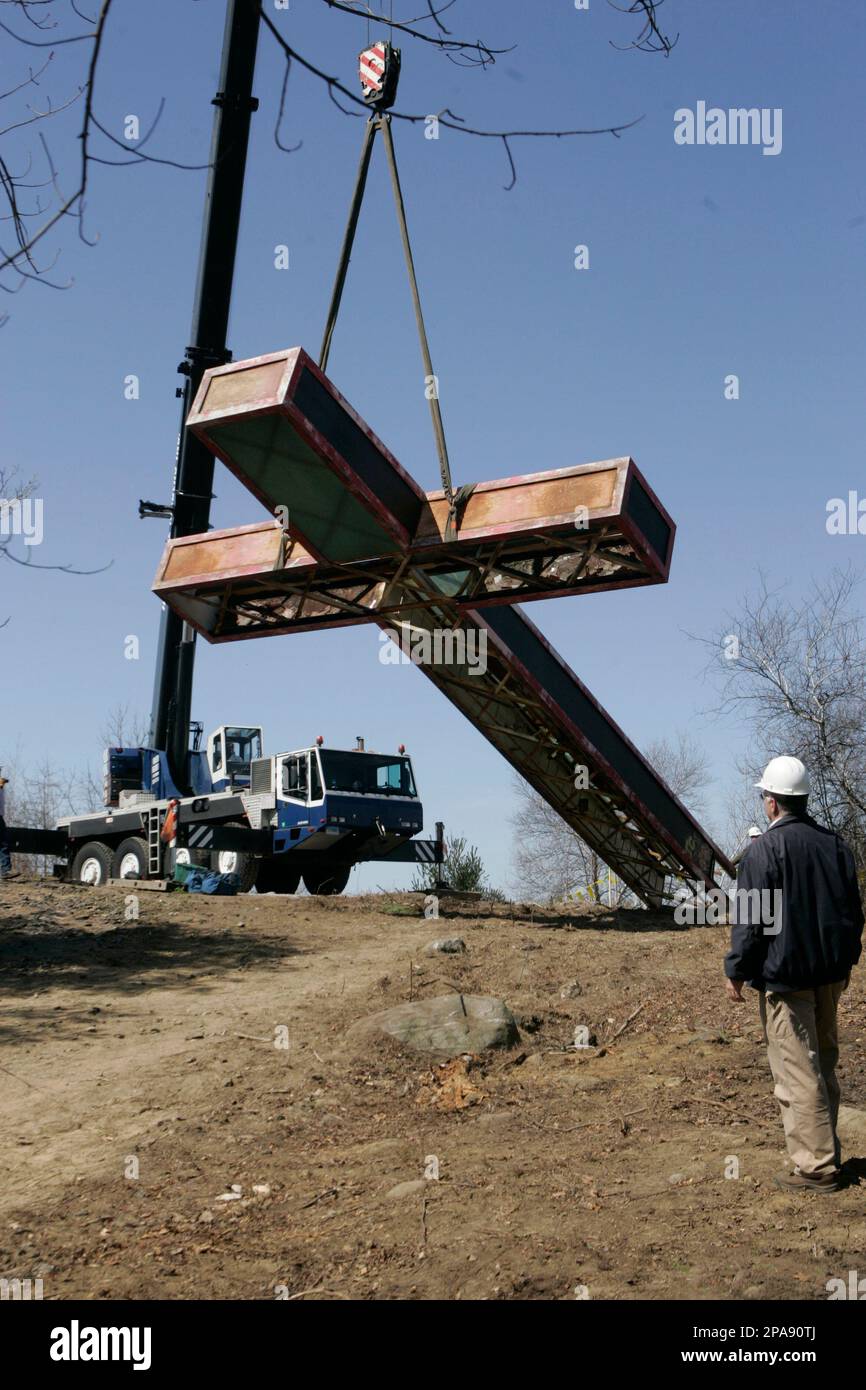 A 50 foot steel cross is dropped to the ground atop Pine Hill, the ...
