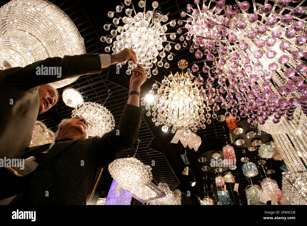 Furniture show attendees check out crystal chandeliers in the Picasso ...