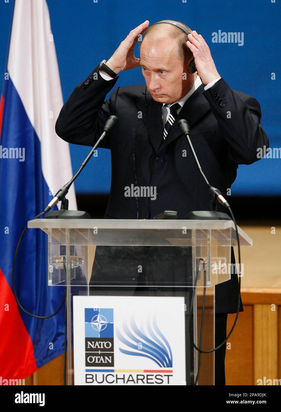 Russian President Vladimir Putin adjusts his headphones, during a press ...