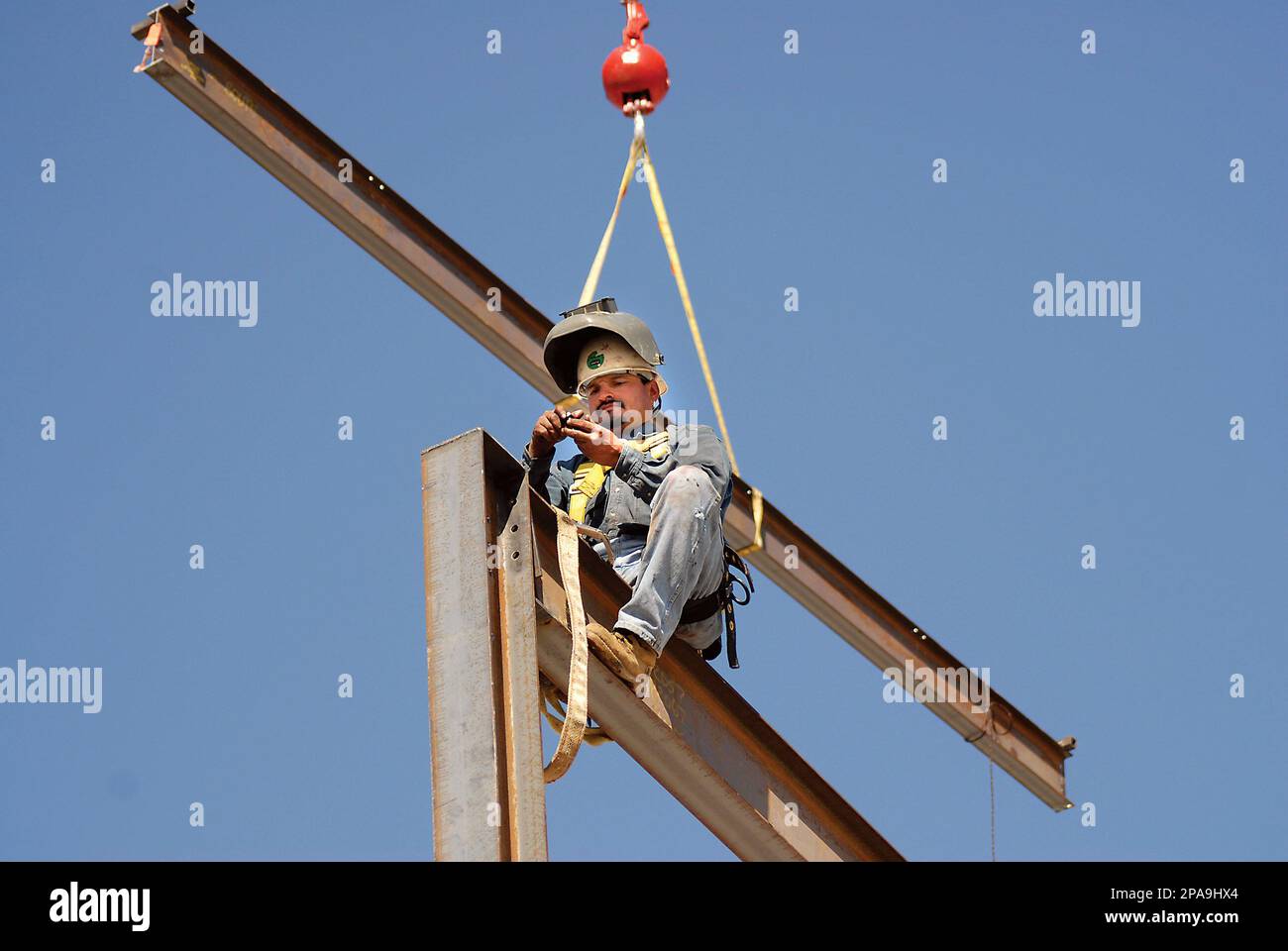 Manny Vigil sits astride a steel beam some 20 feet in the air above the ...