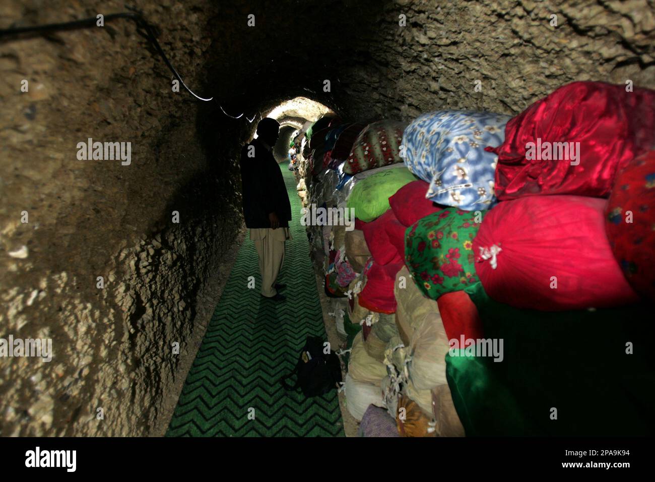 A Pakistani visitor stands inside caves where tattered copies of Quran ...