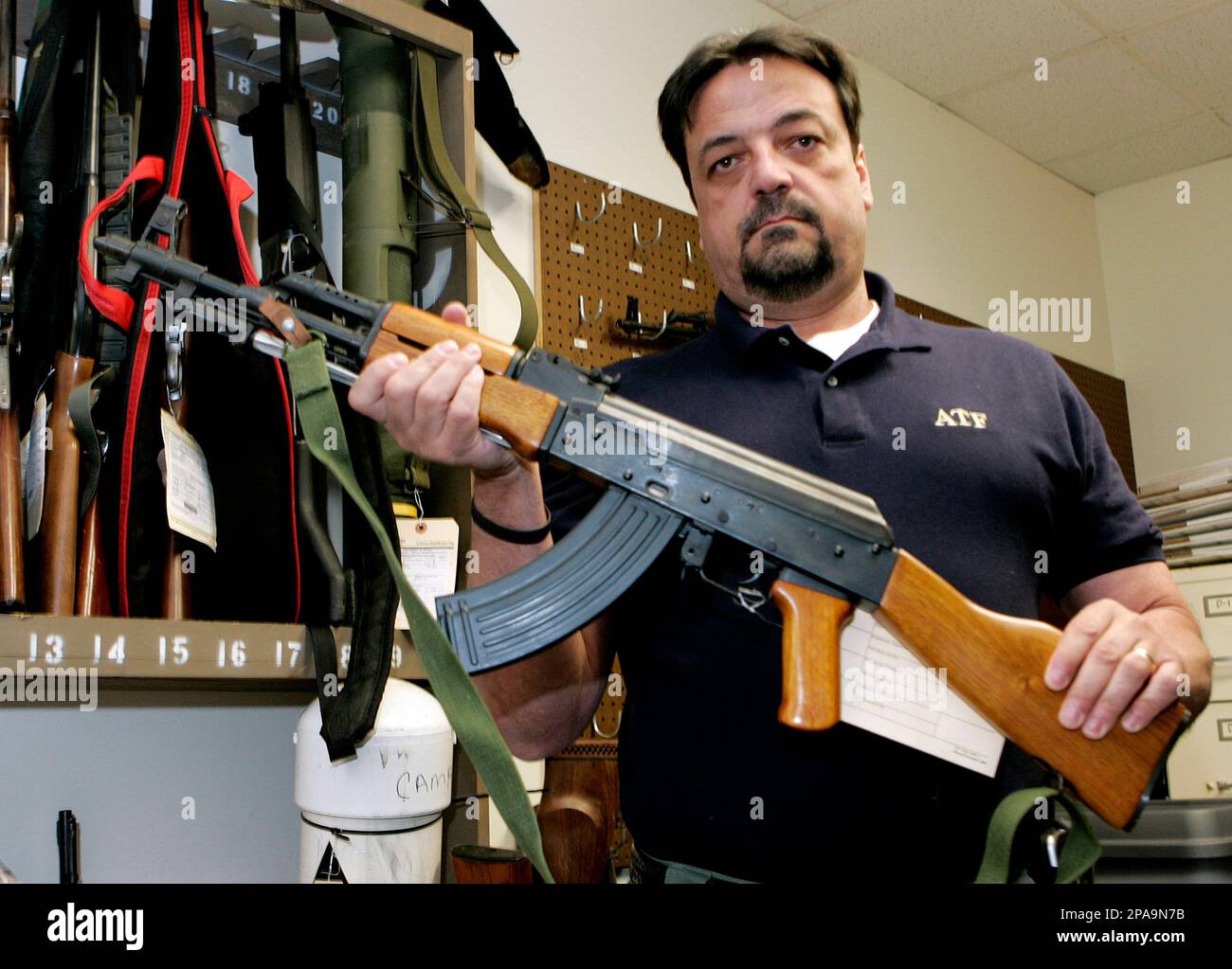 ATF officer Carlos Baixauli holds an AK-47 in Miami Friday, Feb.29 ...