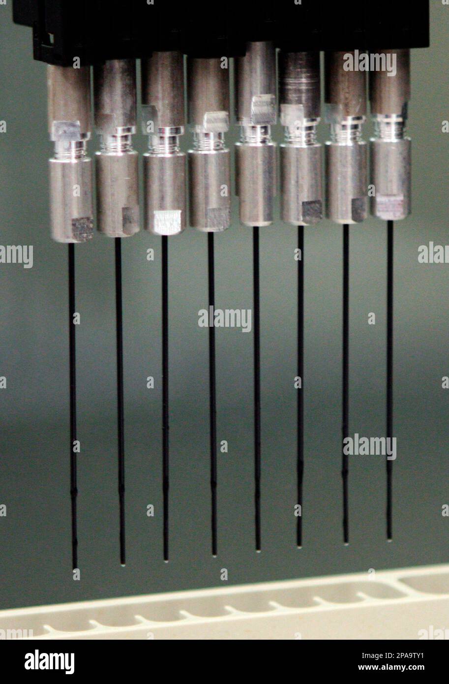 A robotic arm prepares to put drops of DNA-bearing solution on a slide ...