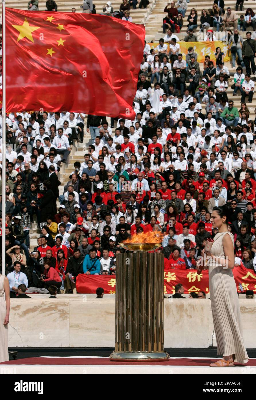 Actress Maria Nafpliotou dressed as high priestess stands next to the ...