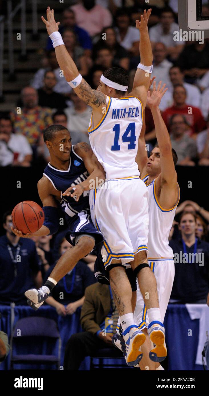 Xavier's Stanley Burrell, left, passes around UCLA's Lorenzo Mata-Real ...