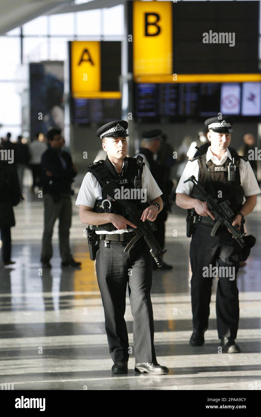 Armed police officers patrol the departure lounge of the new Terminal 5 ...