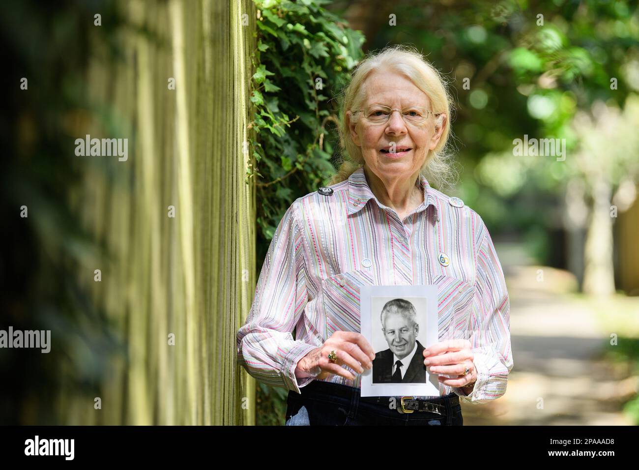 Jennifer Adam poses for a photograph with a photo of her father Eric ...