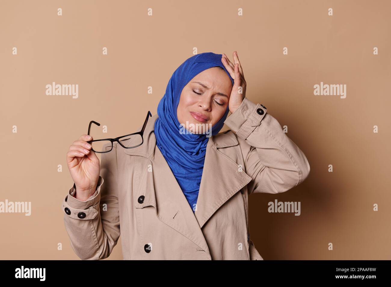 Elegant Arab Muslim pretty woman in blue hijab, puts off her spectacles ...