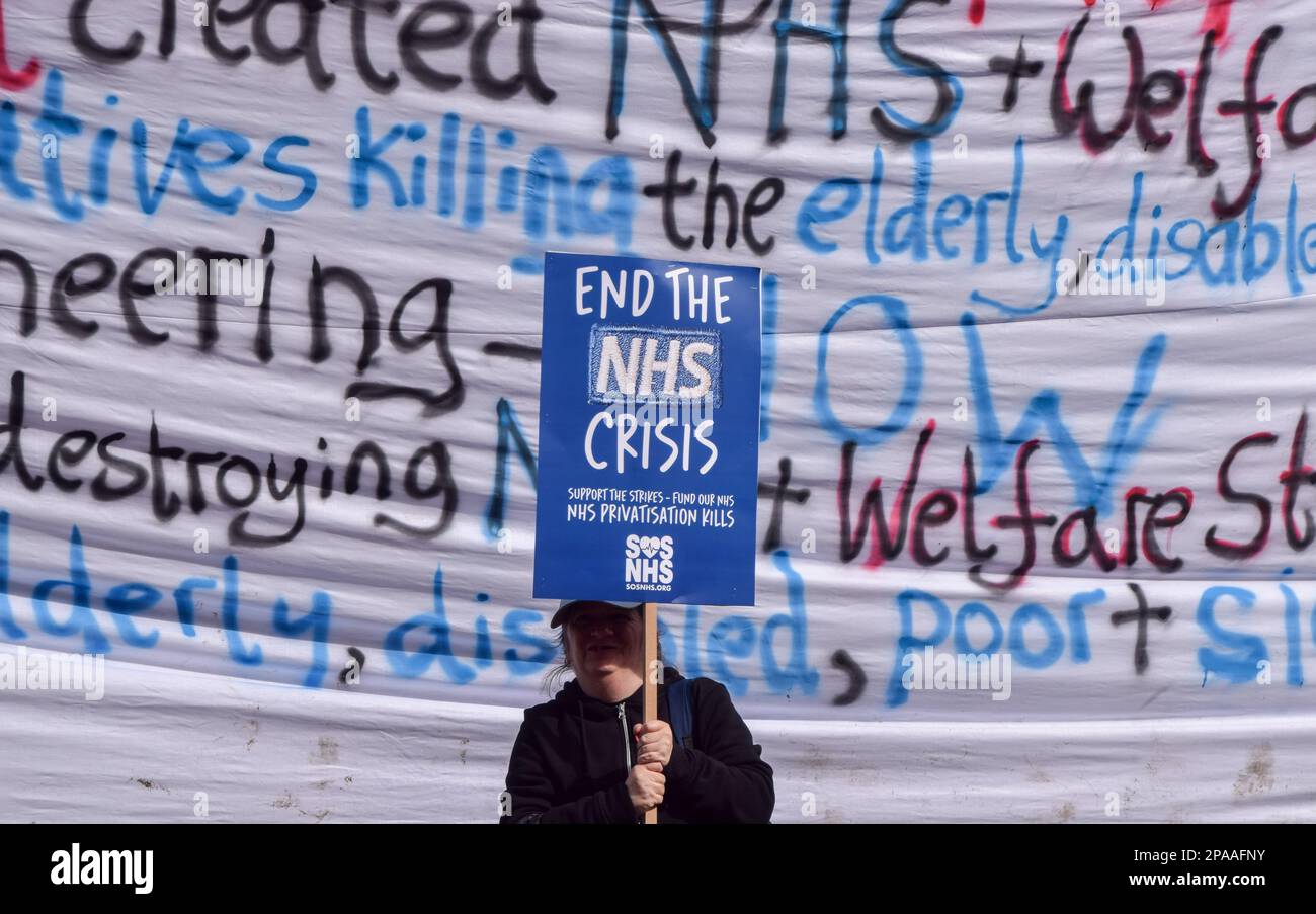 London, UK. 11th Mar, 2023. A protester holds an 'End the NHS crisis ...