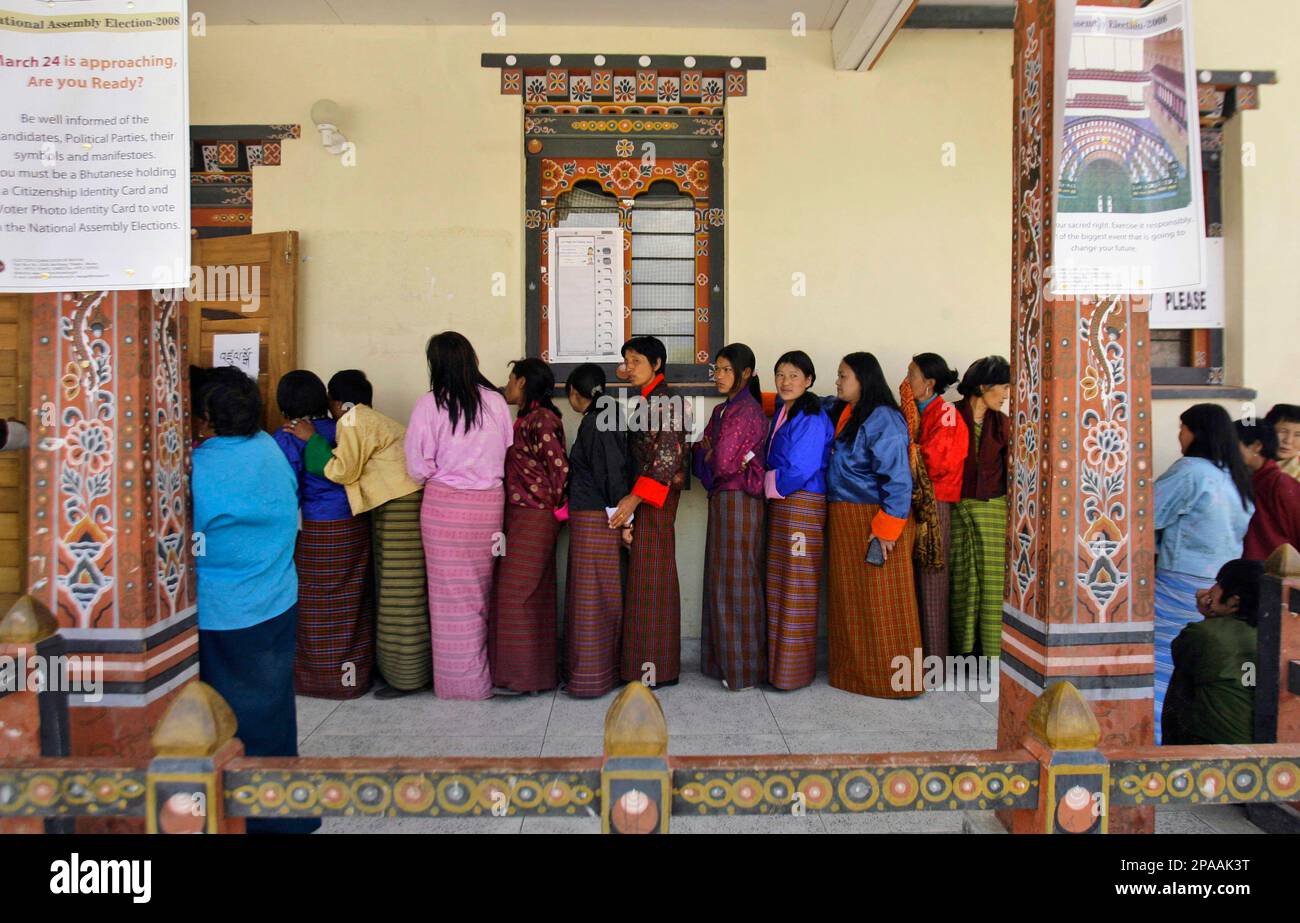 Bhutanese women queue up to cast their votes outside a polling station ...